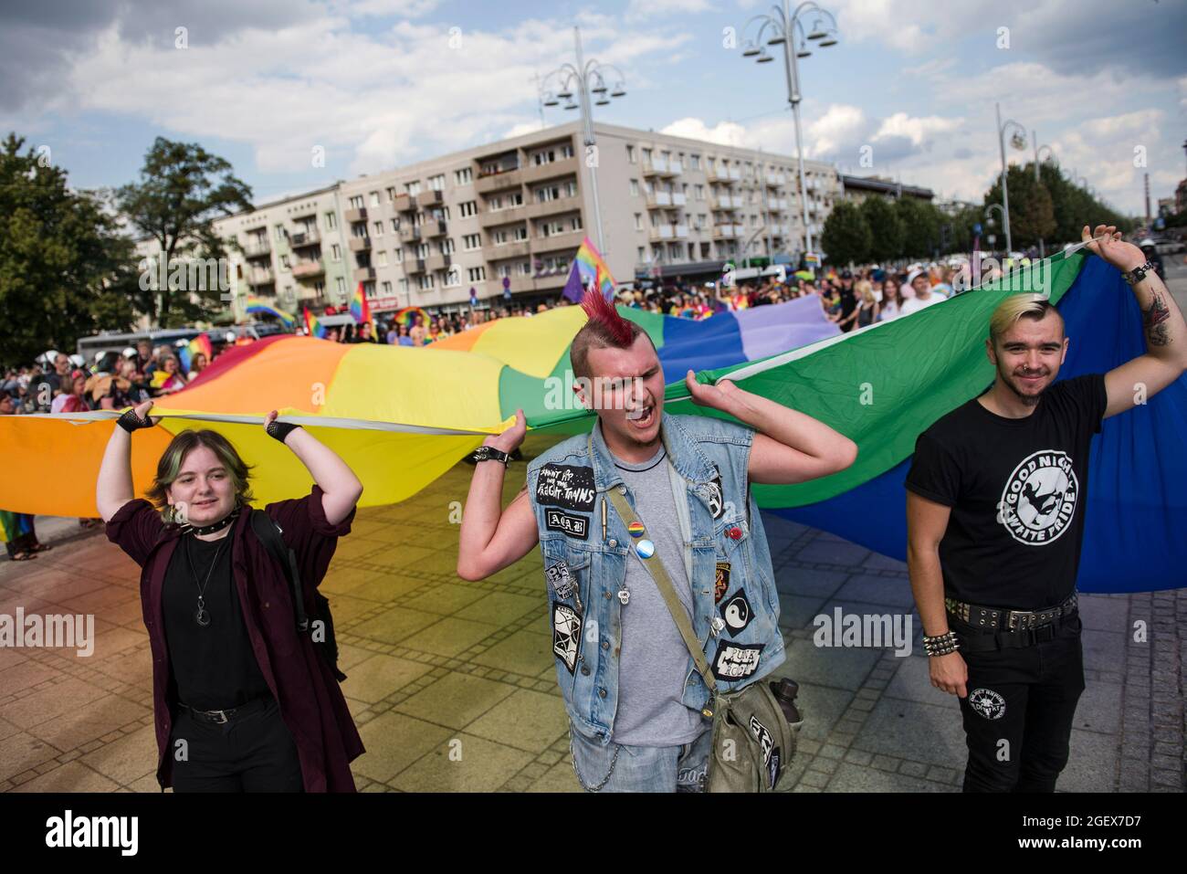 Participants shouting slogans and holding a massive rainbow flag during ...