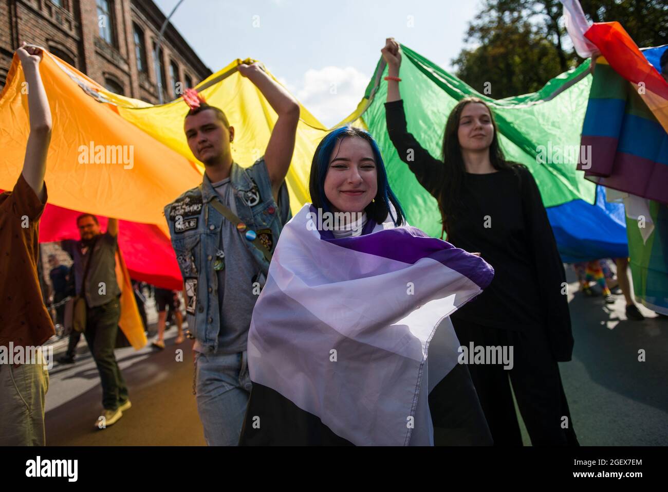 A participant wrapped in a flag smiles during the march.Hundreds of ...