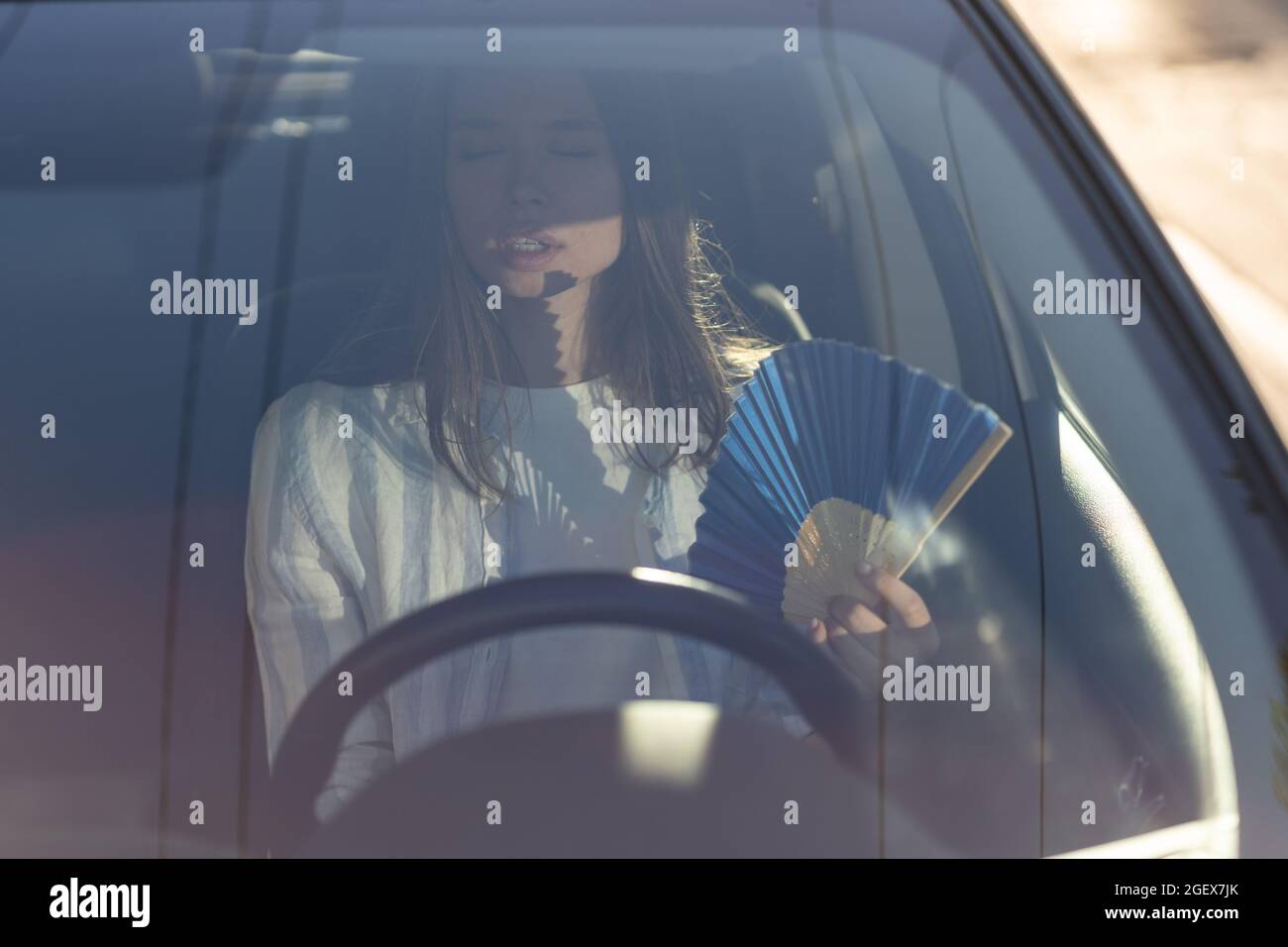 Young girl driver suffer from heat in car wave fan with broken air ...