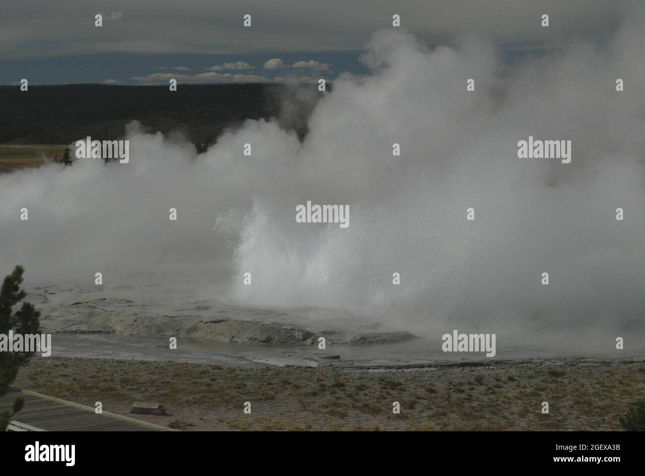 A wide column of water erupts from a pool and produces a lot of steam ...
