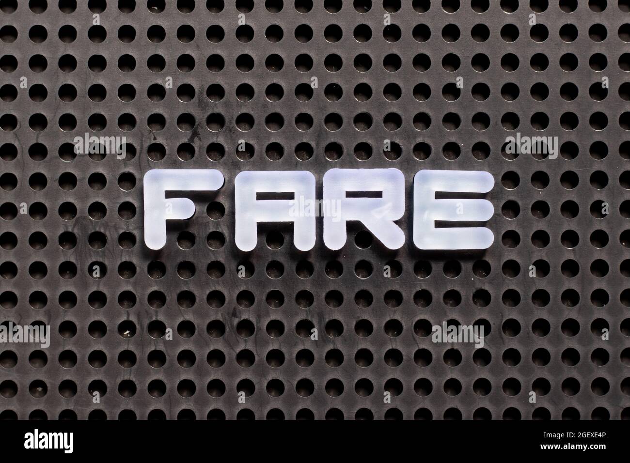White color letter in word fare on black pegboard background Stock ...