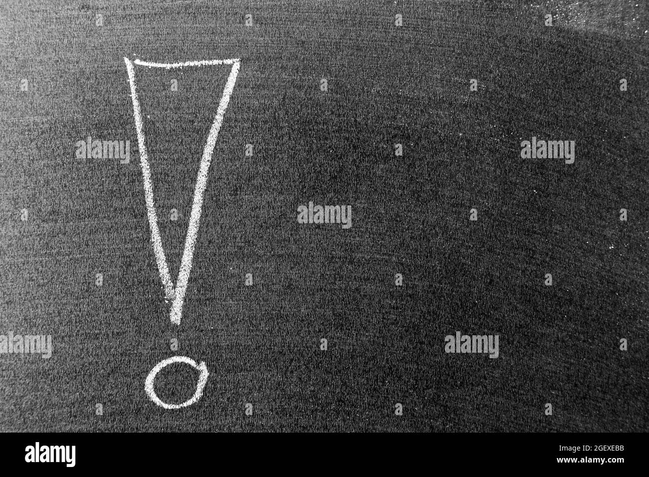White color chalk hand drawing in exclamation mark with blank space ...