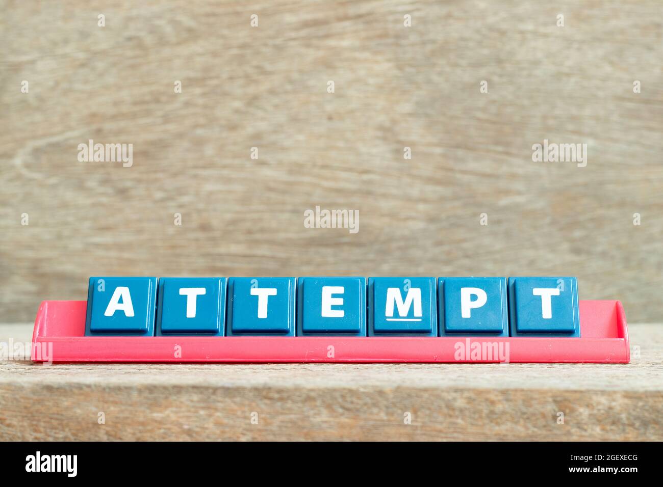 Tile alphabet letter with word attempt in red color rack on wood ...