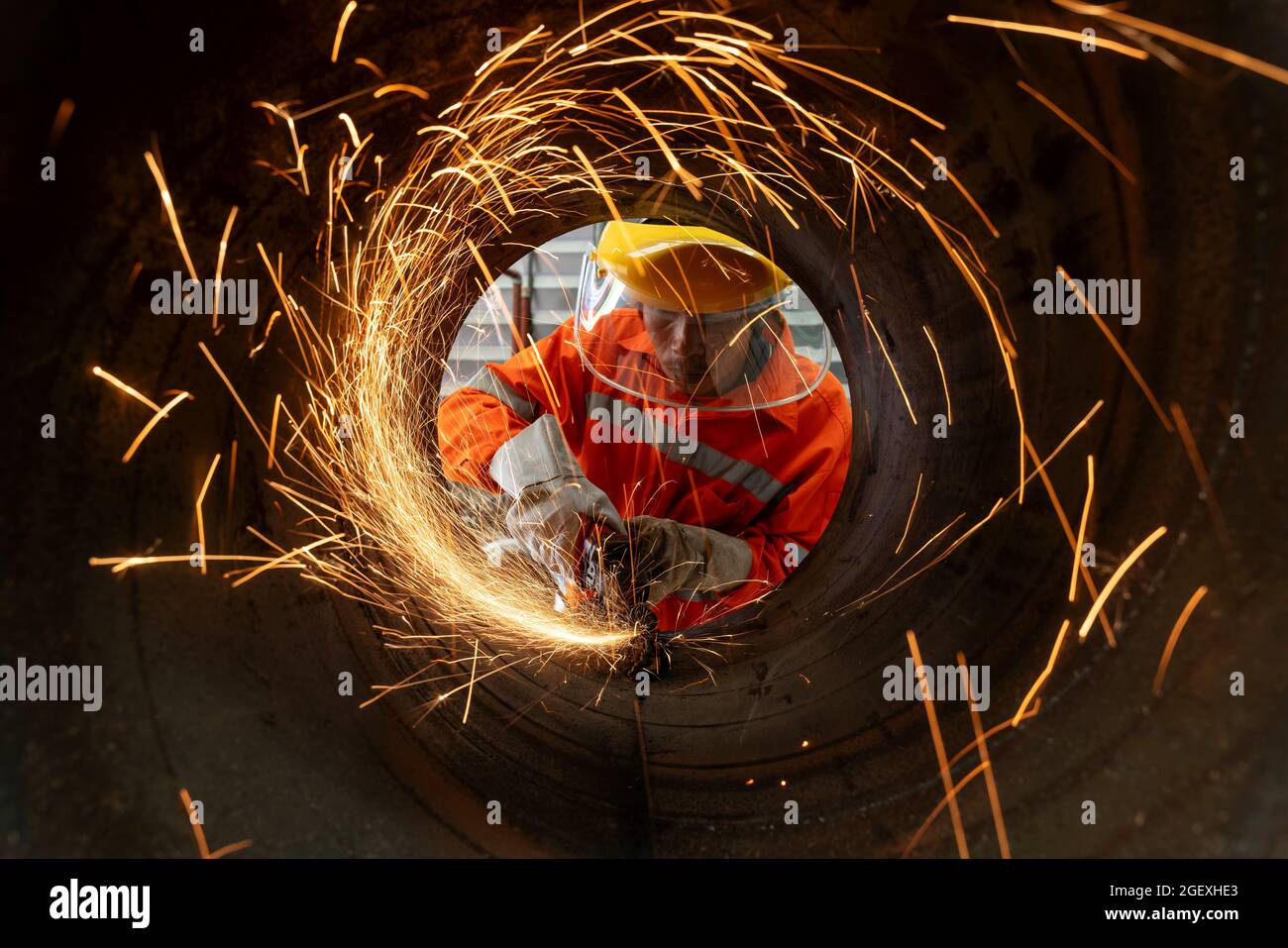 An Electric wheel grinding at Industrial worker cutting metal pipe with ...