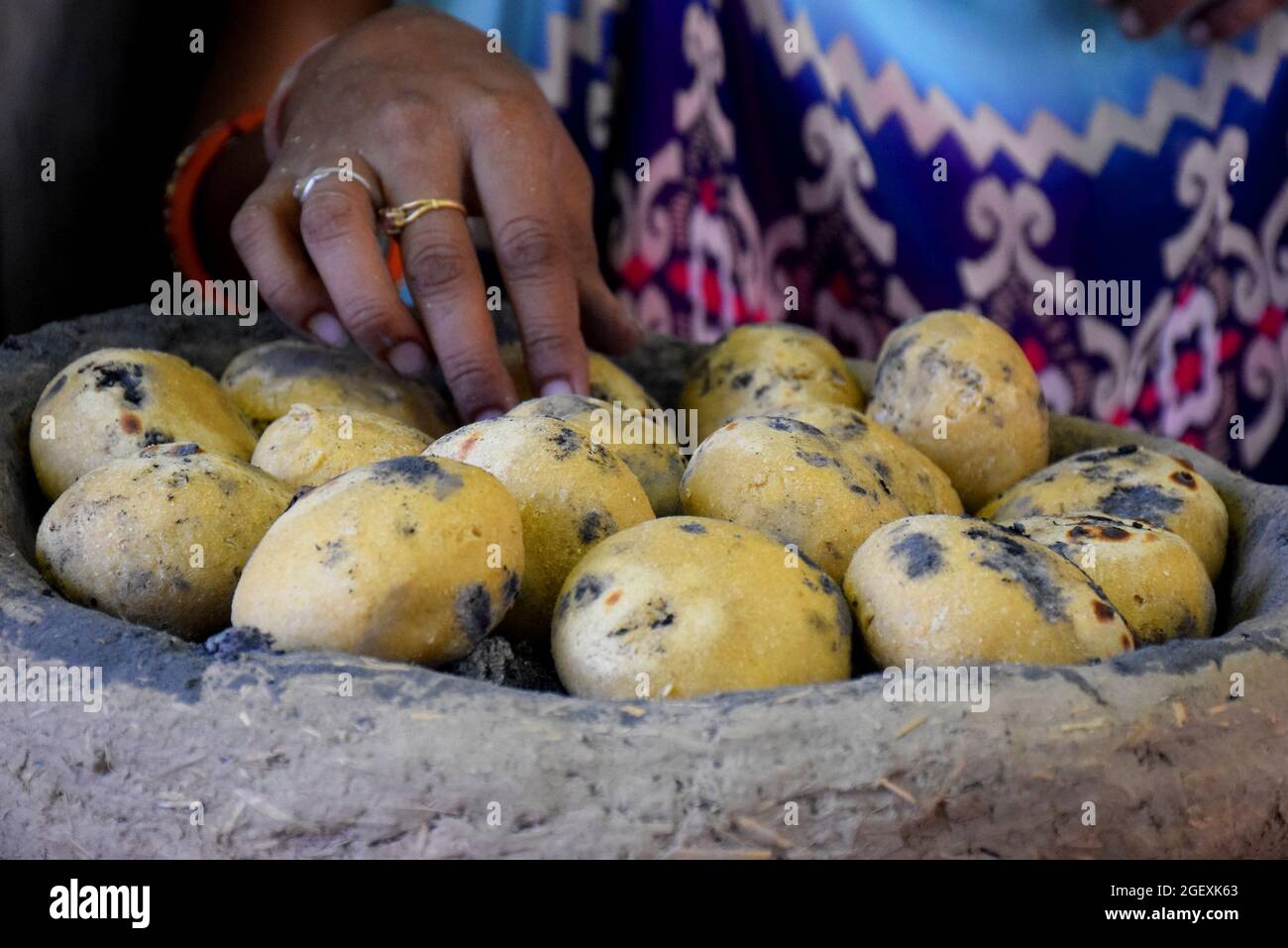 Indian rural woman's hands baking bread in earthen pot Stock Photo - Alamy
