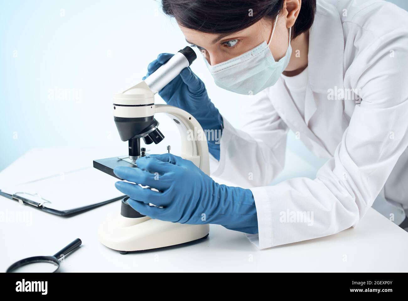 female doctor looking through a microscope biotechnology research ...