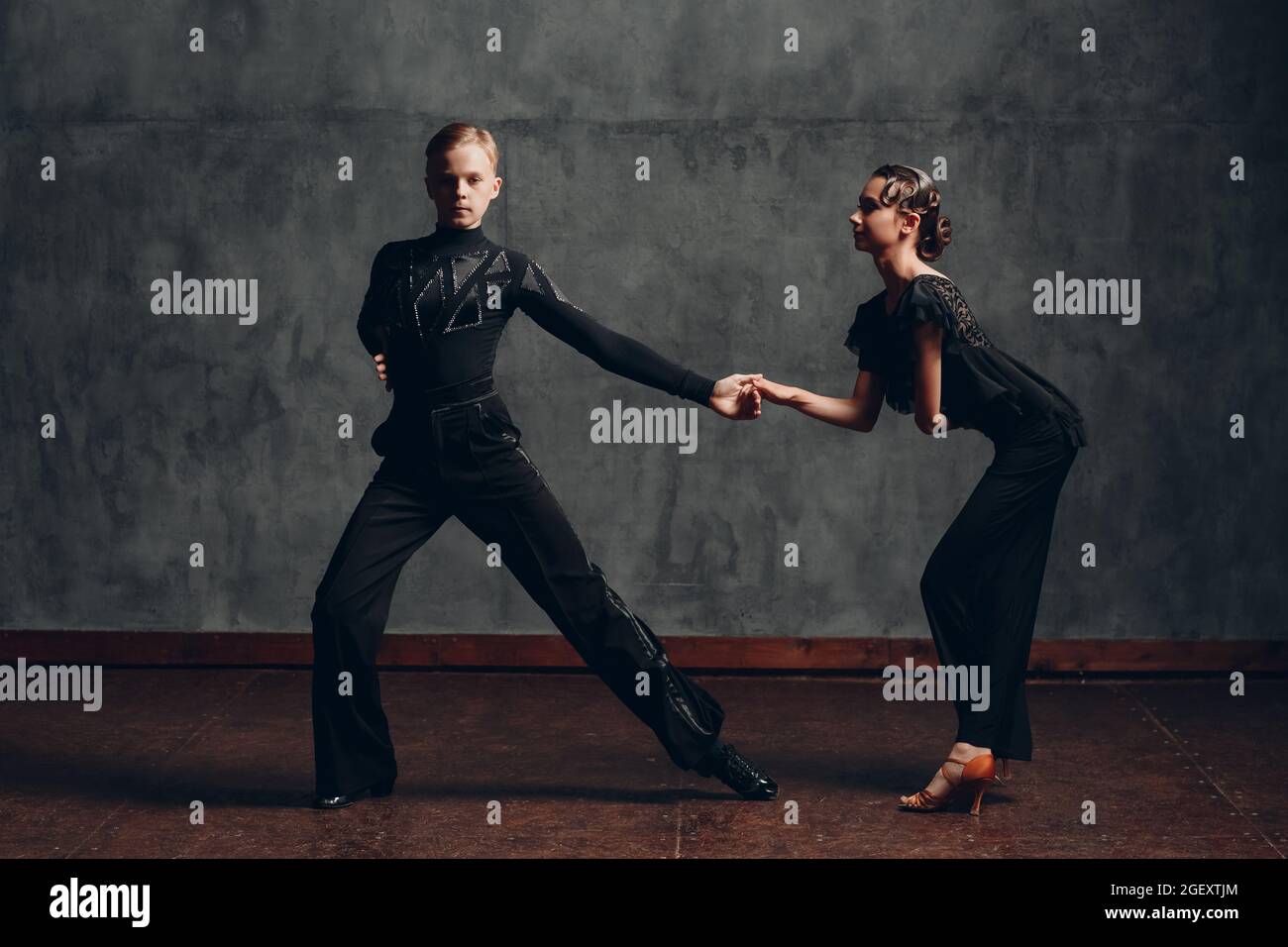 Couple young man and woman in black dress dancing in ballroom dance ...