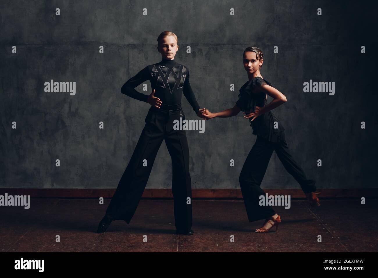 Couple in black costumes dancing in ballroom rumba dance Stock Photo ...