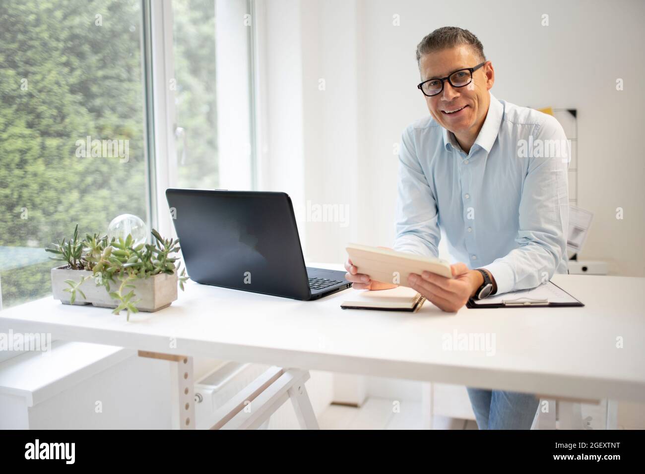 business man with blue shirt and black glasses is standing behind ...