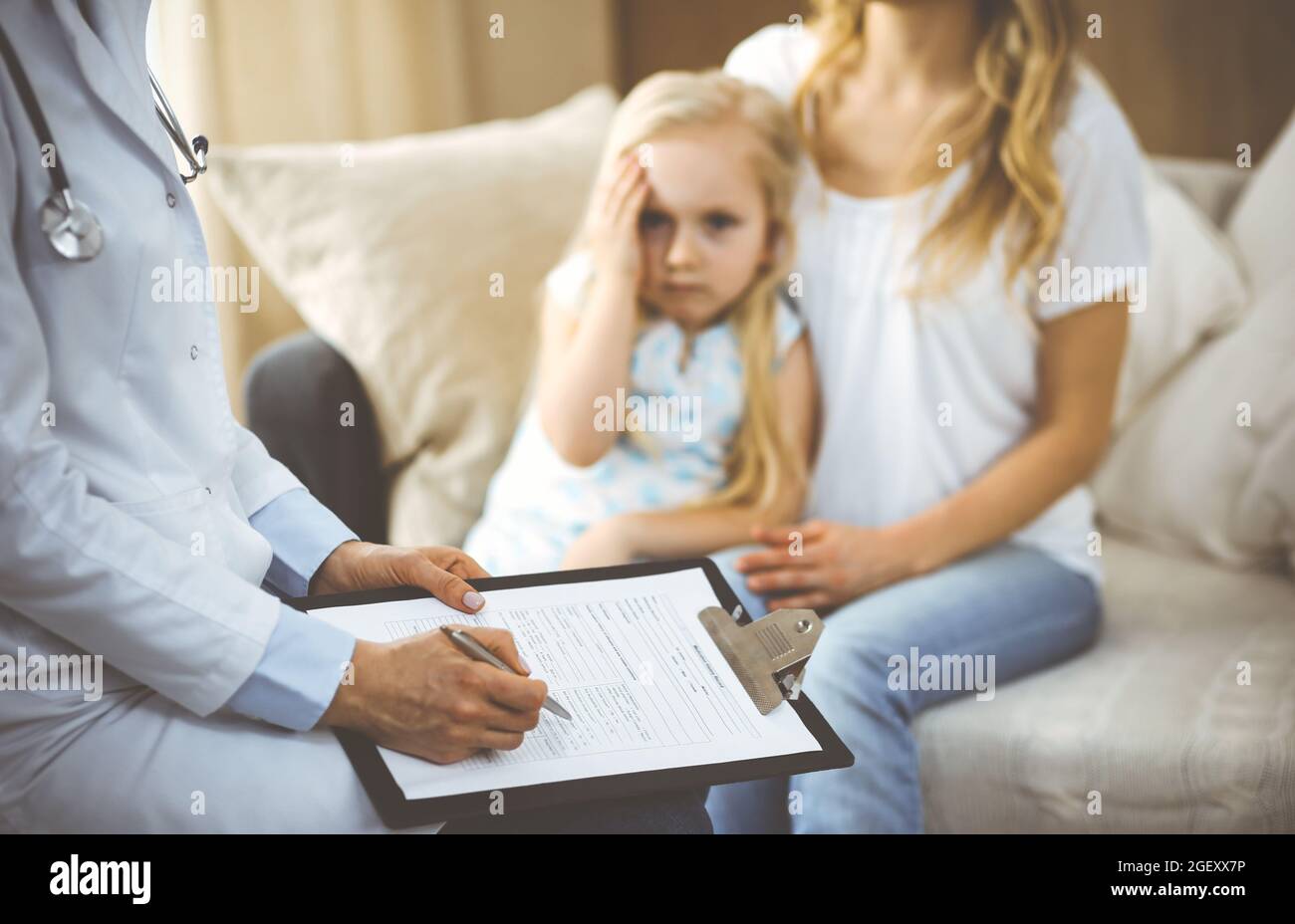 Doctor and patient. Pediatrician using clipboard while examining little ...