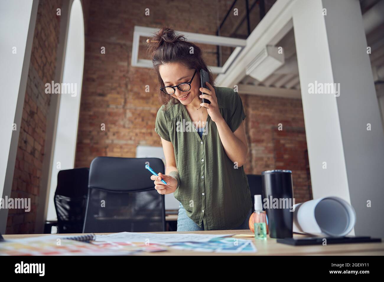 Smiling creative woman, interior designer or architect wearing glasses ...