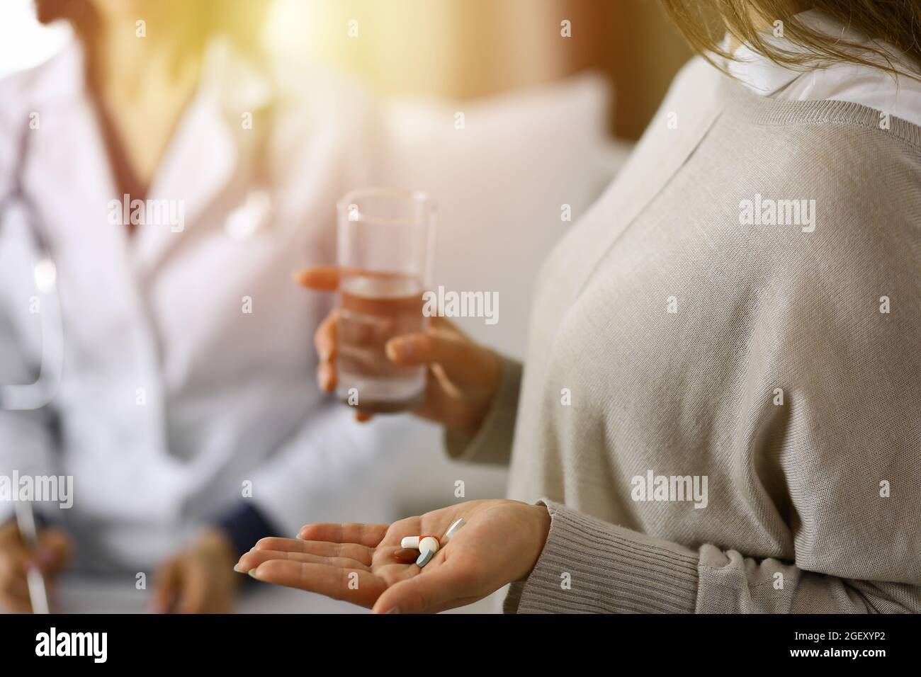 Close-up woman-patient holding pills near her doctor, time to take ...