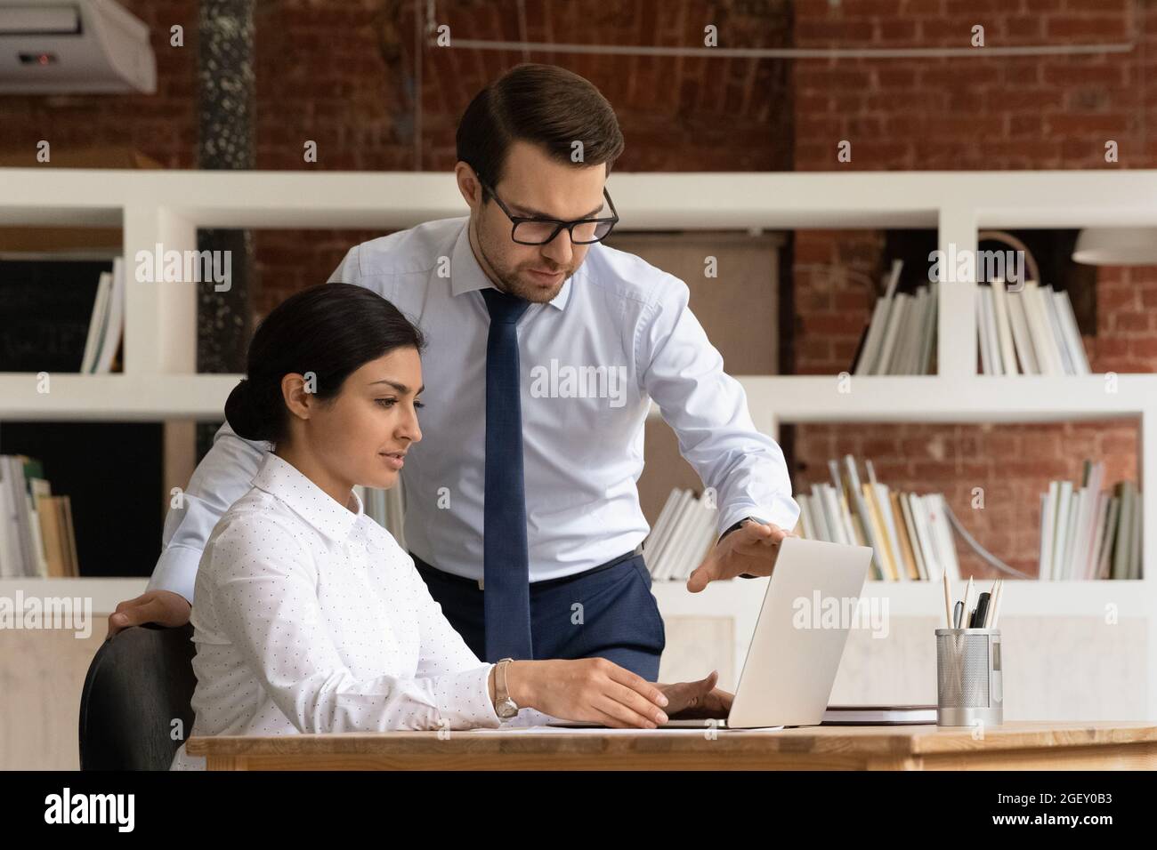 Mentor helps to Indian employee with corporate software Stock Photo - Alamy