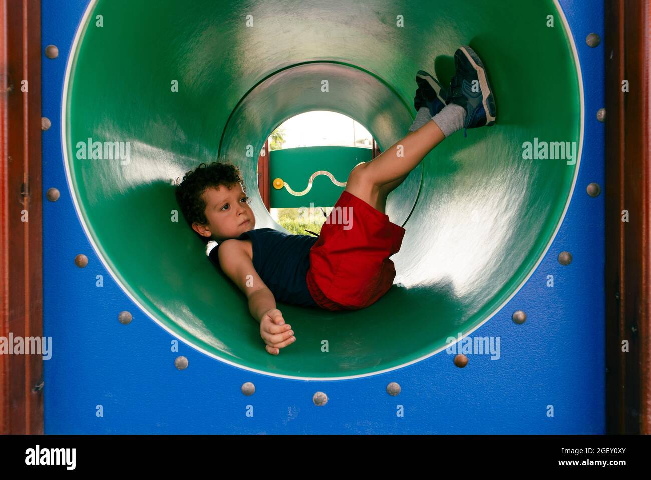 funny child inside a tube in a playground game Stock Photo - Alamy