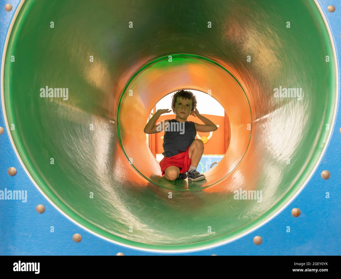 funny child inside a tube in a playground game Stock Photo - Alamy