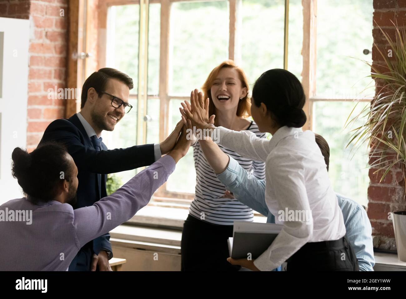 Group of happy colleagues feel motivated giving high five Stock Photo ...