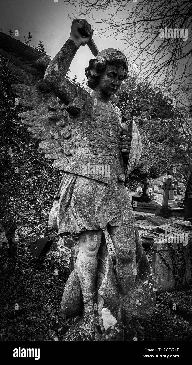 A vertical grayscale shot of a beautiful angel statue in Highgate ...