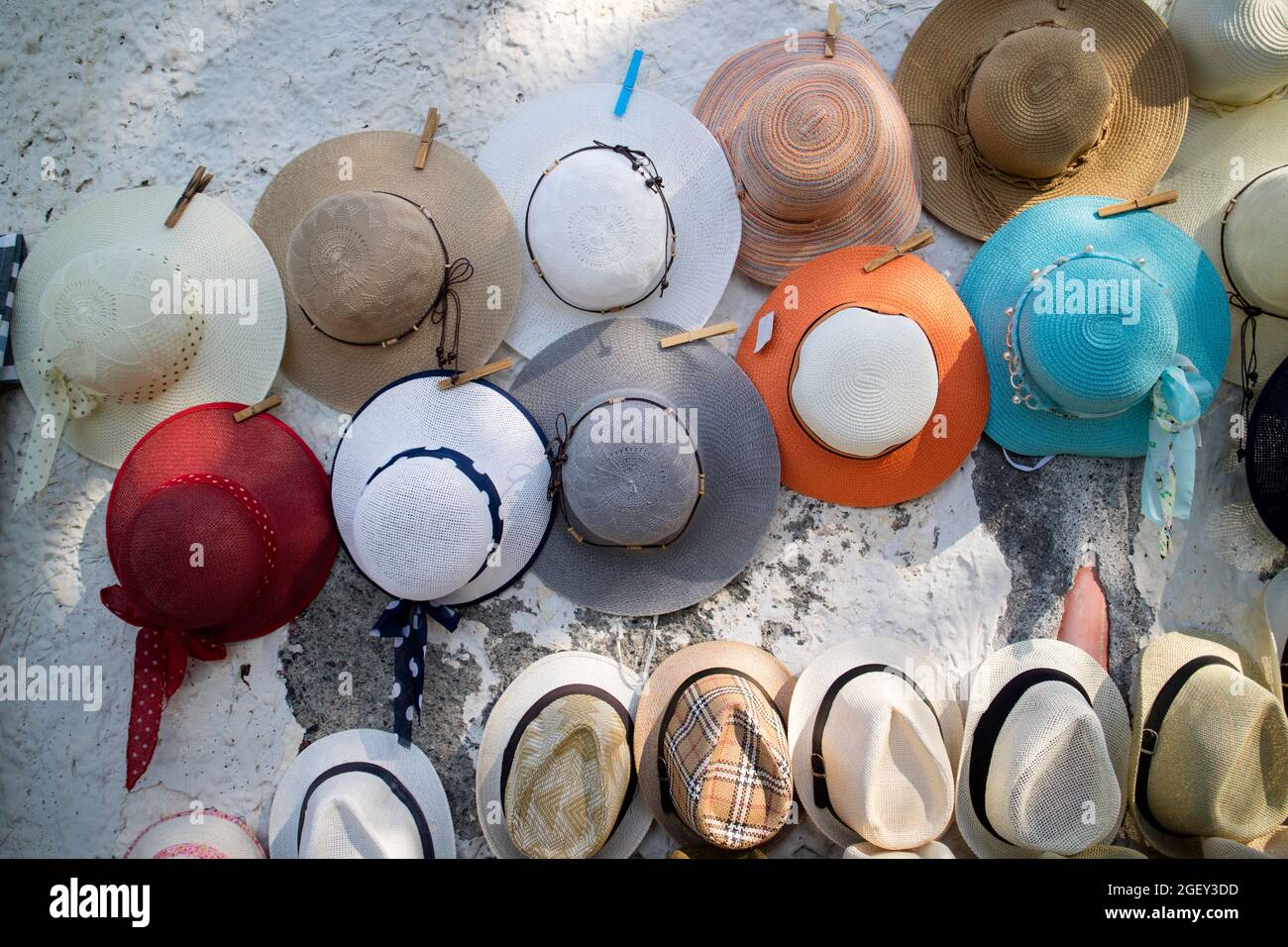 Display of a series of hats hanging from a wall in the street Stock ...