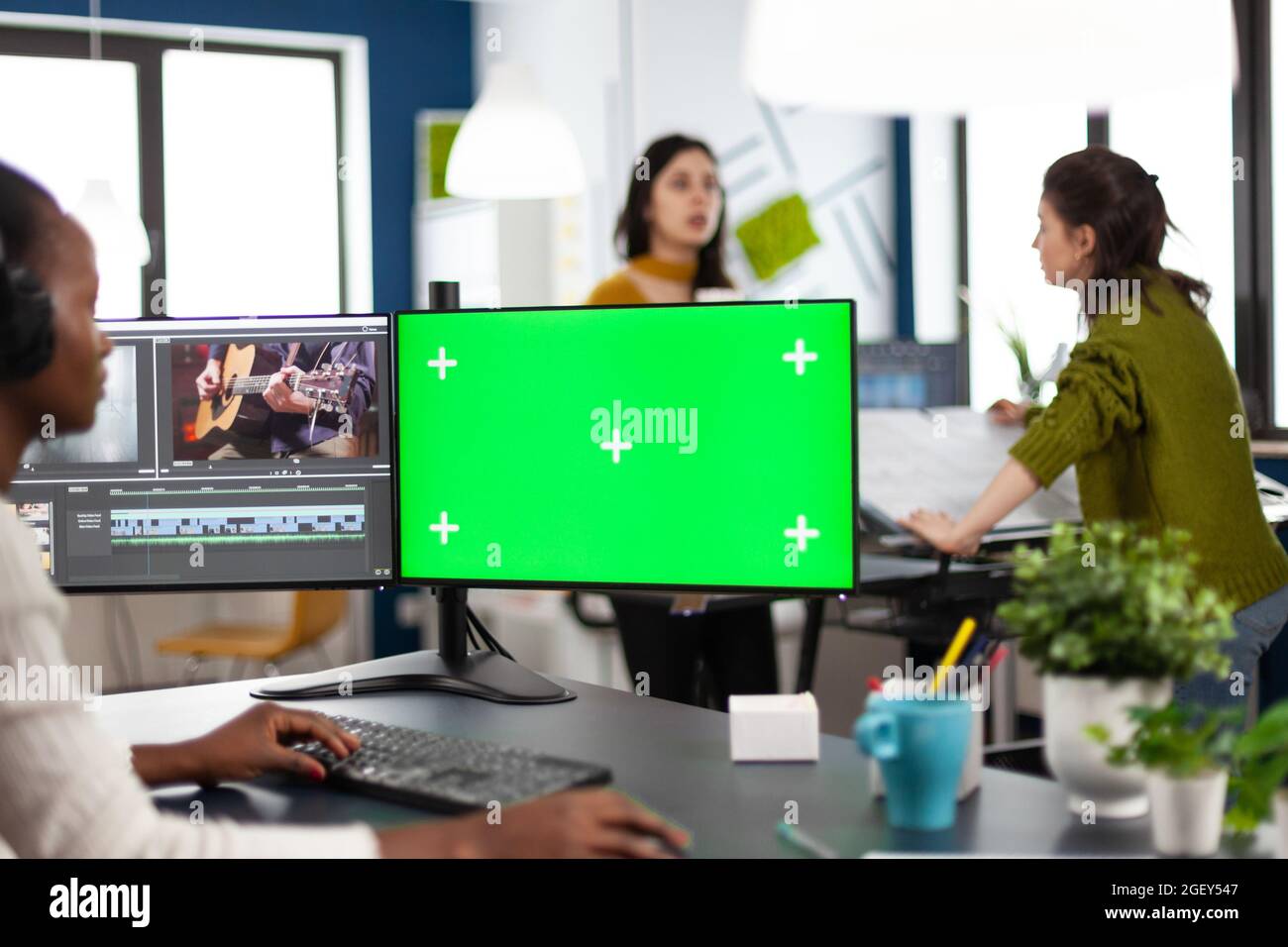 Black woman video editor with headphones using with green screen ...