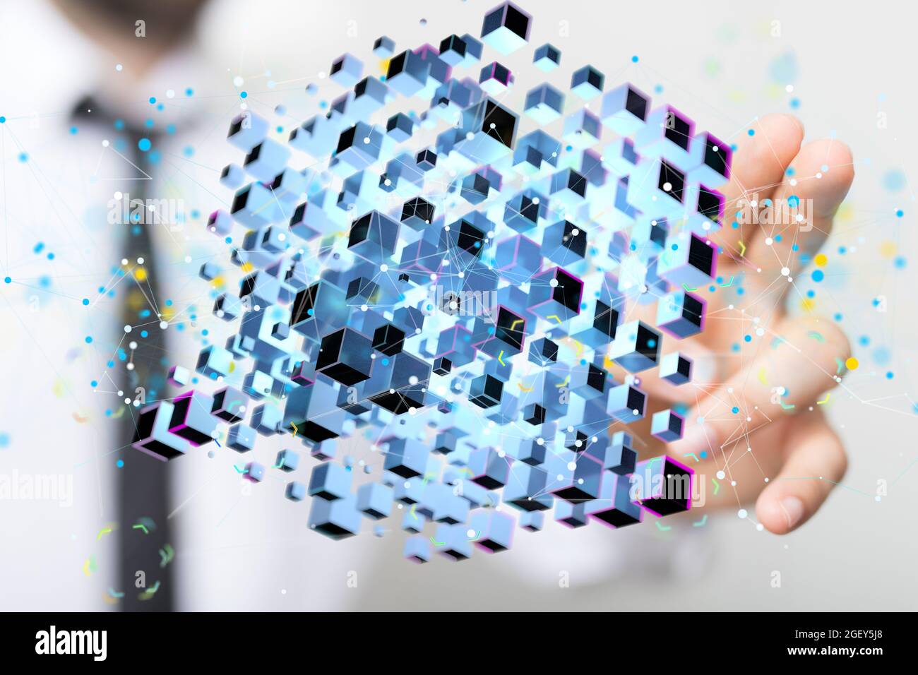 A businessman holding a virtual cube depicting information stored in a ...