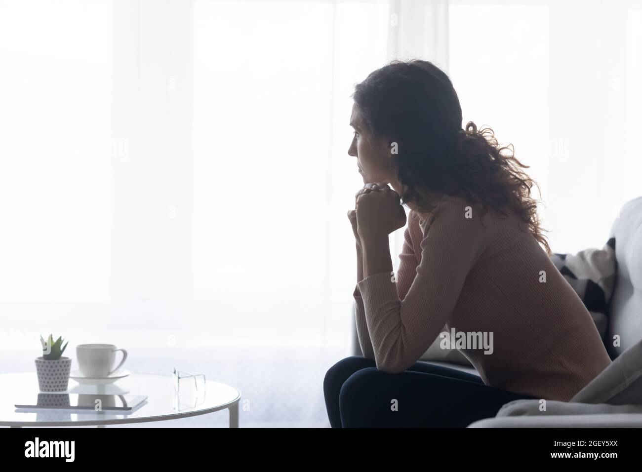 Thoughtful serious woman sitting on couch looking out window Stock ...