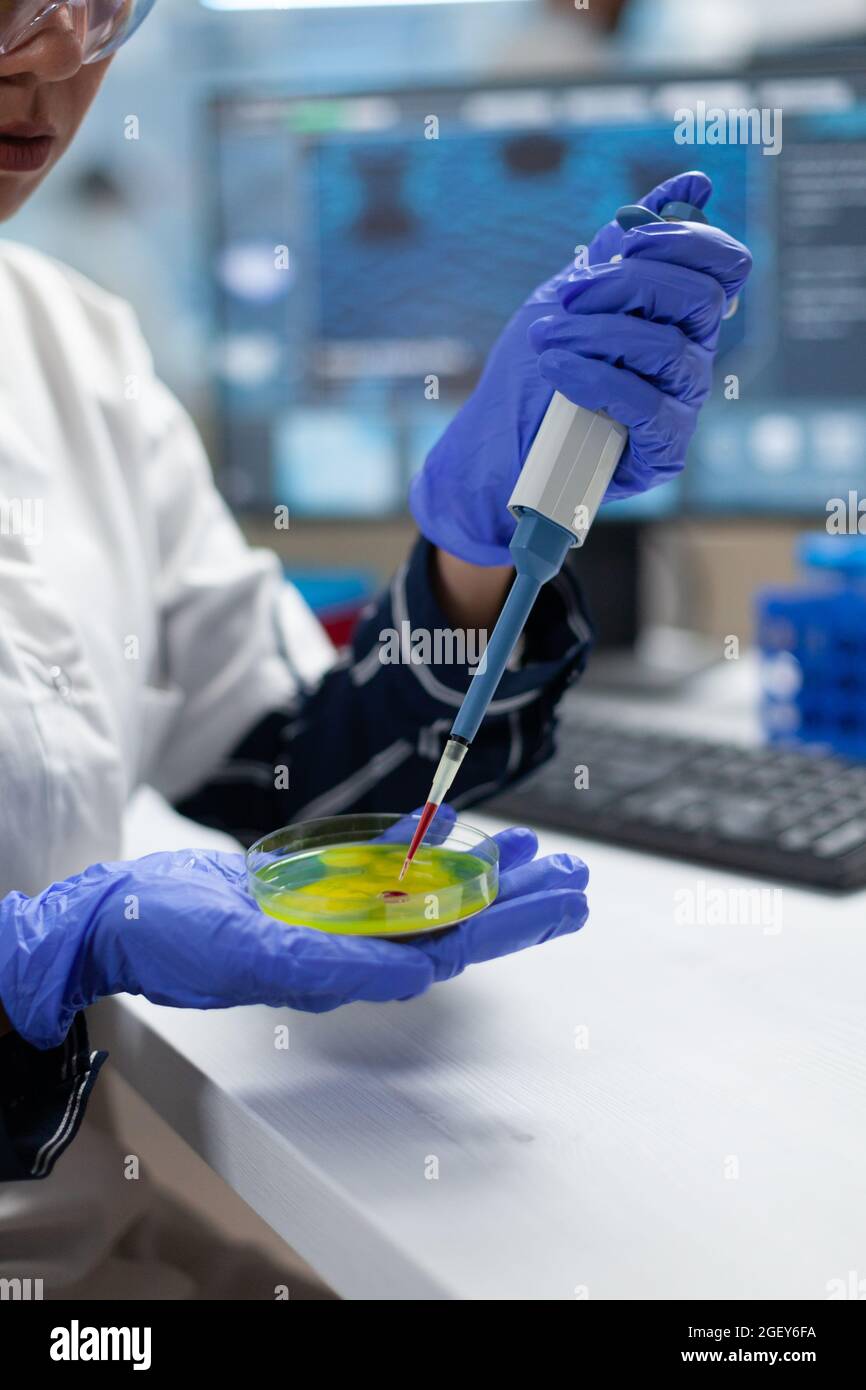 Close up of woman biologist researcher hands putting liquid sample in ...