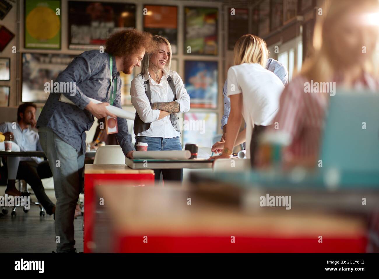 group of people gathered around the table, standing, smiling, talking ...