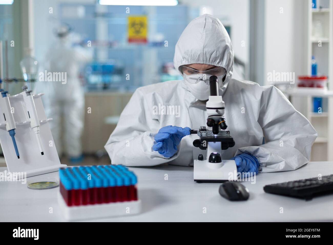 Biologist researcher wearing ppe medical suit analyzing genetics sample ...