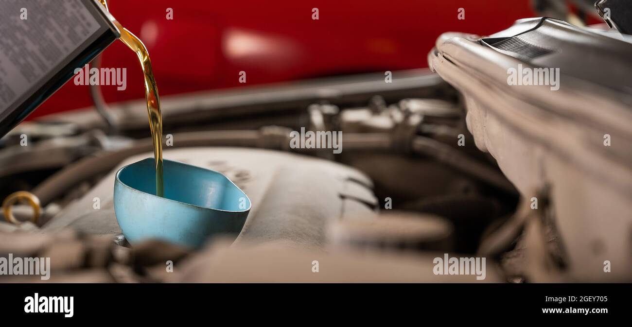 Auto mechanic pours oil into a car engine Stock Photo - Alamy