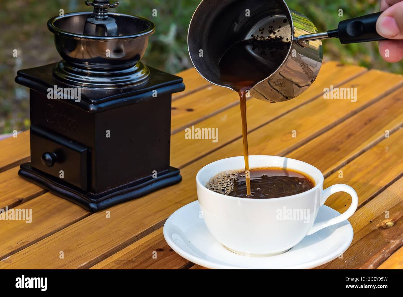 Fresh coffee from a cezve pouring in cup Stock Photo - Alamy