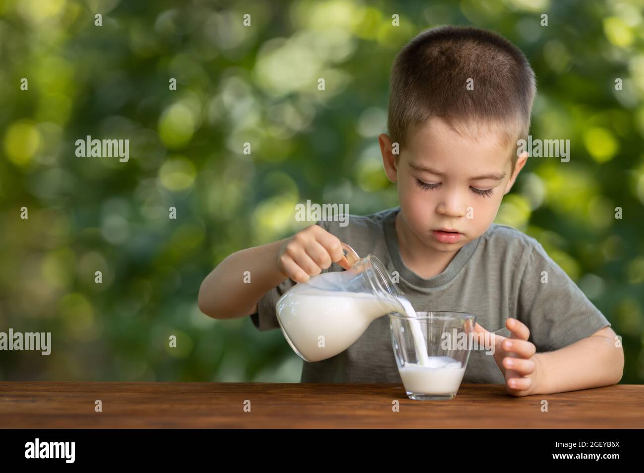 little independent boy pouring milk into glass Stock Photo - Alamy