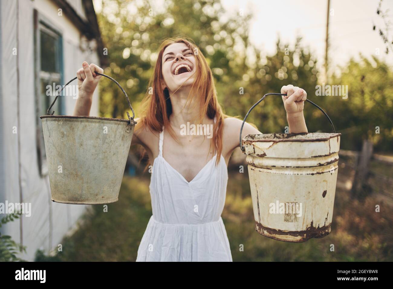 woman in white dress with buckets in hand nature Lifestyle Stock Photo ...