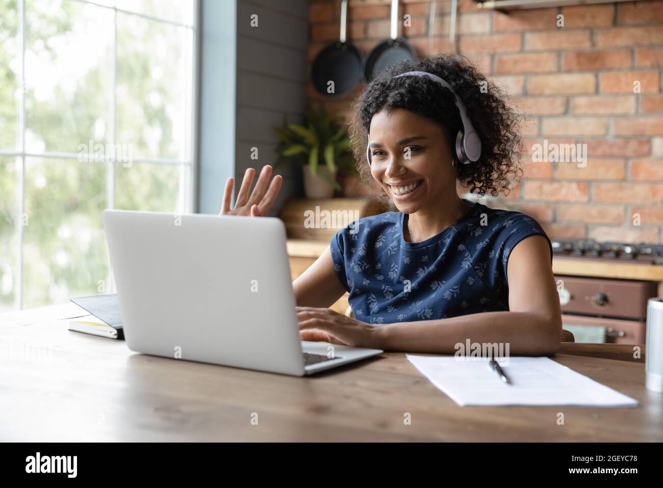 Happy Black student girl in wireless earphones attending virtual ...