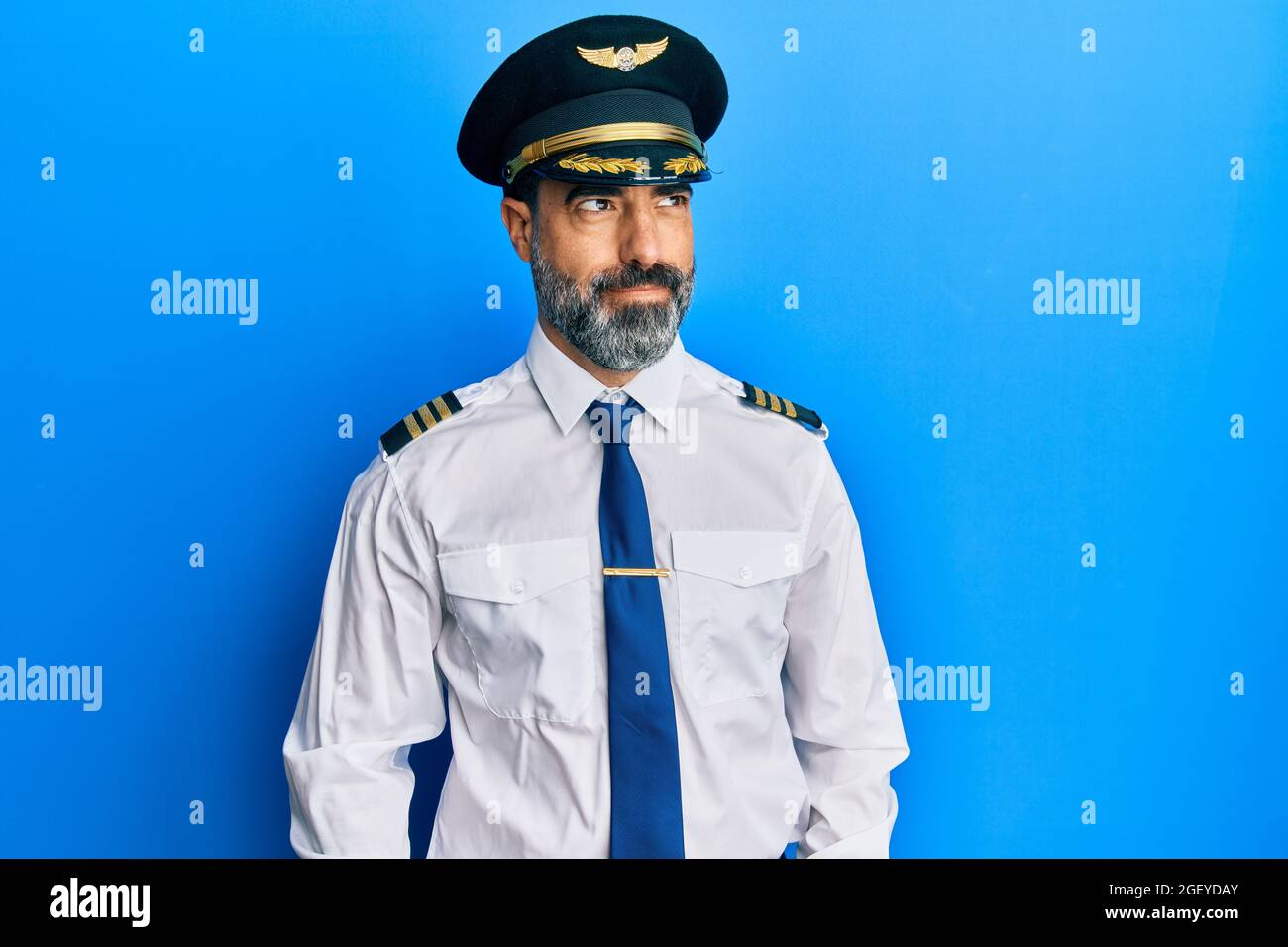 Middle age man with beard and grey hair wearing airplane pilot uniform ...