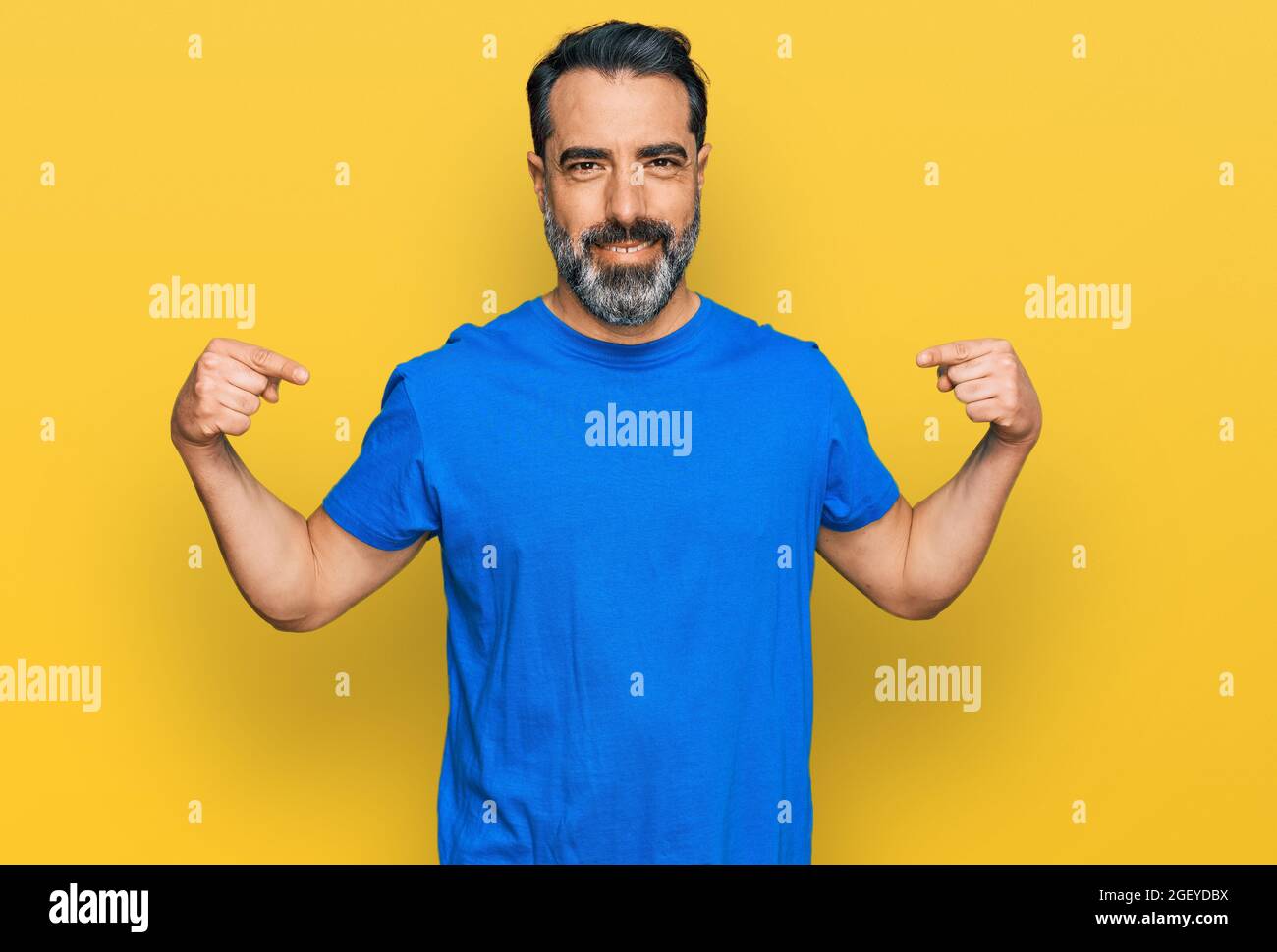 Middle aged man with beard wearing casual blue t shirt looking ...