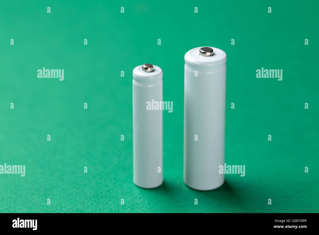 Several AA batteries in close up on a green background. Alkaline ...