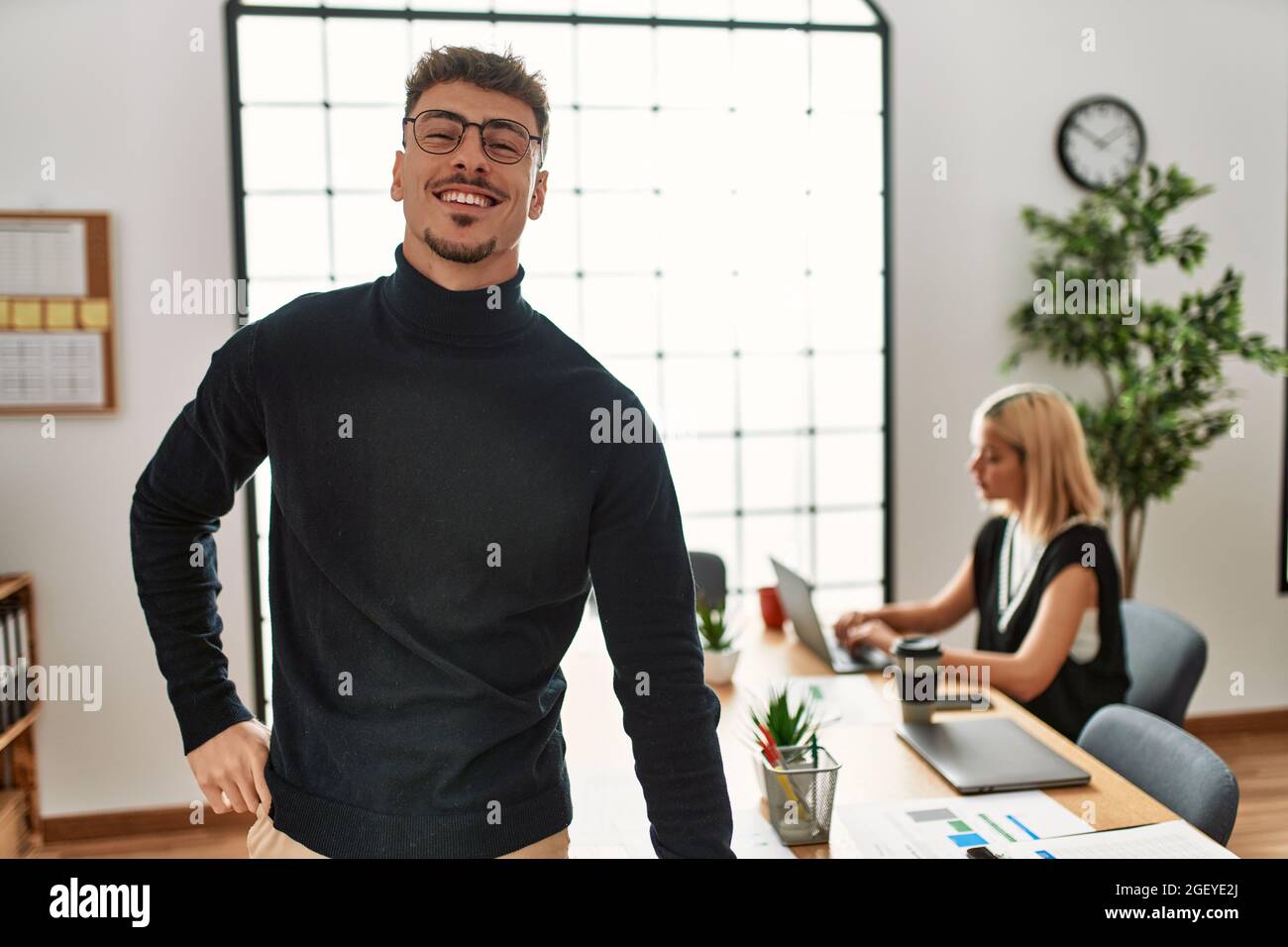 Two business workers smiling happy working. Man standing at the office ...