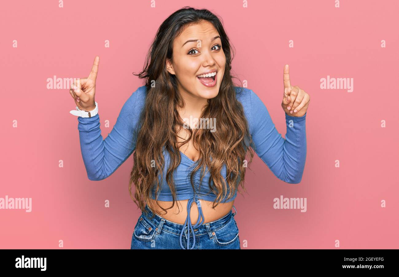 Young hispanic girl wearing casual clothes smiling amazed and surprised ...