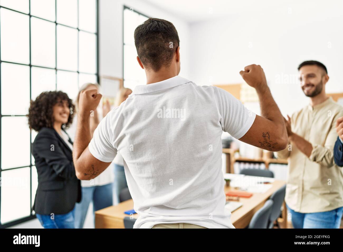 Group of young business workers smiling and clapping. Young businessman ...