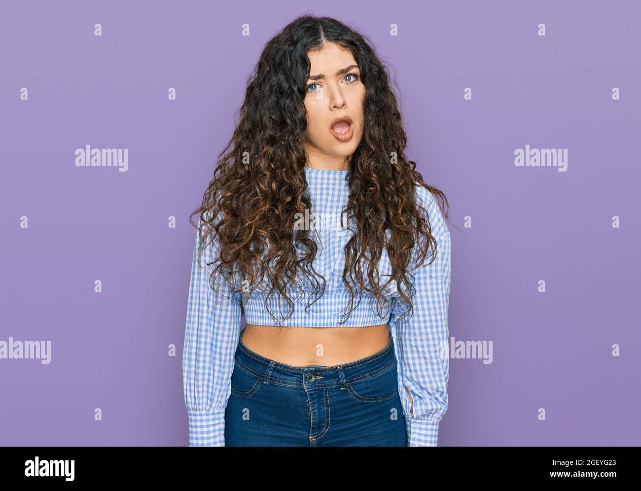 Young hispanic girl wearing casual clothes in shock face, looking ...