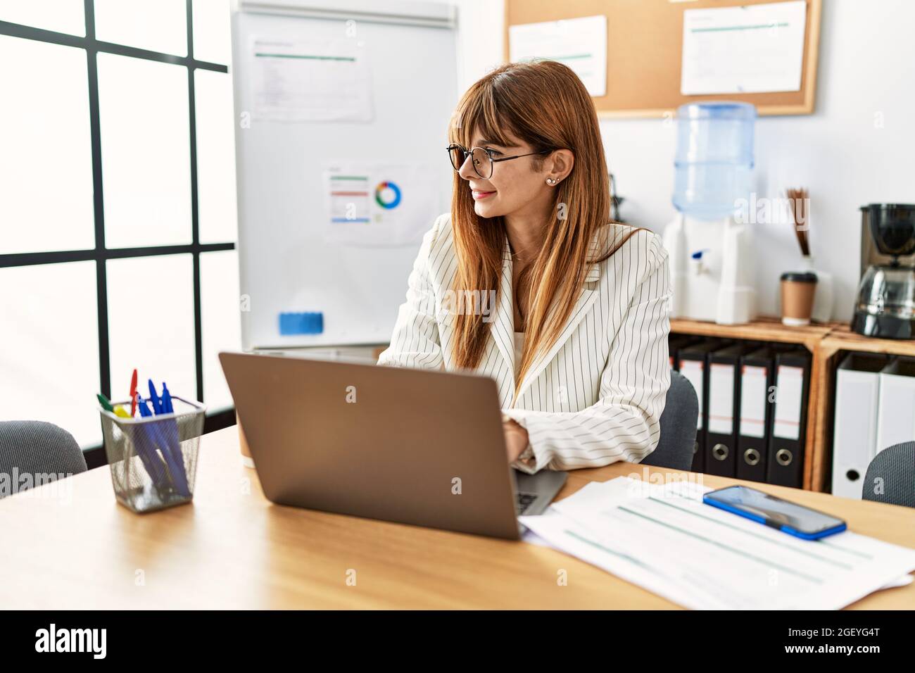 Young hispanic businesswoman smiling happy working at the office Stock ...