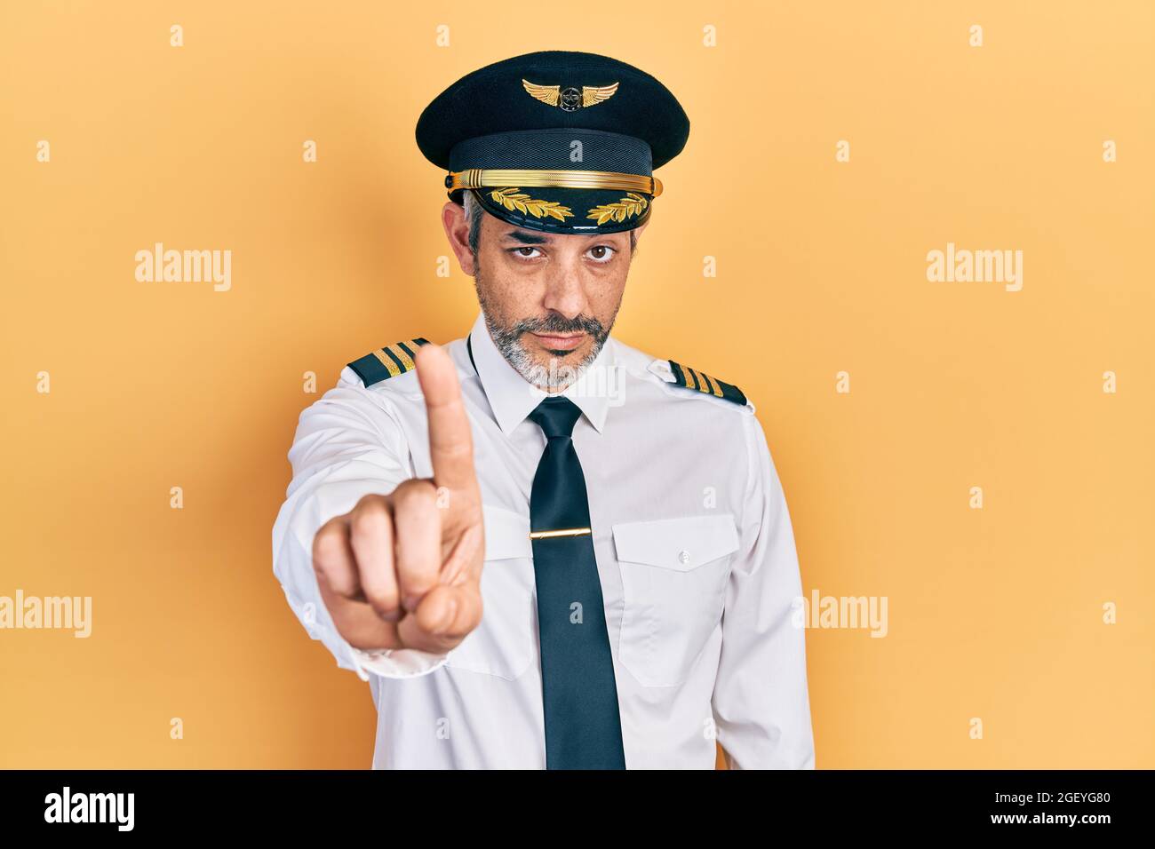 Handsome middle age man with grey hair wearing airplane pilot uniform ...