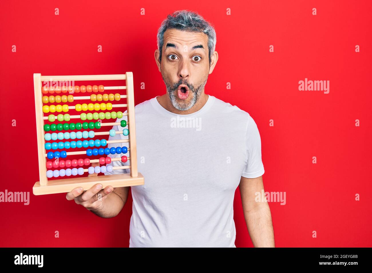 Handsome middle age man with grey hair holding traditional abacus ...
