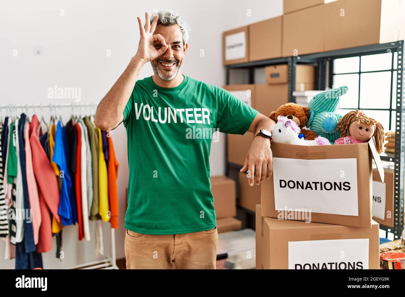 Middle age hispanic man wearing volunteer t shirt at donations stand ...