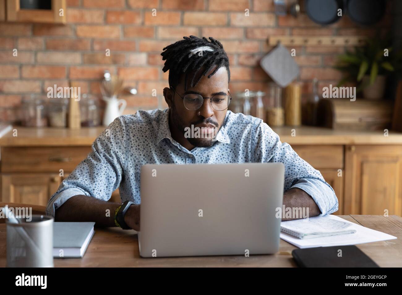 Focused African student guy studying from home, watching learning ...