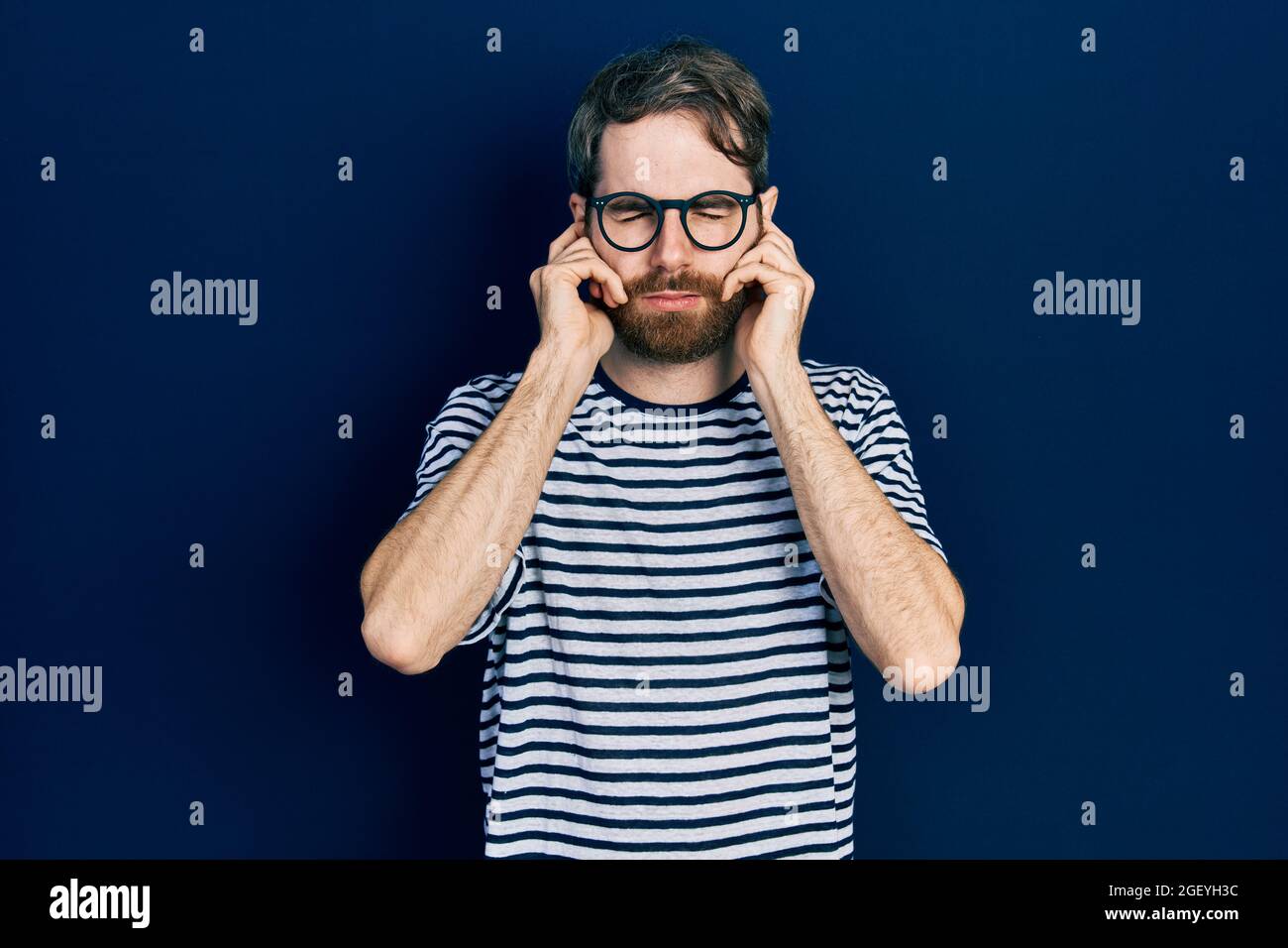 Caucasian man with beard wearing striped t shirt and glasses covering ...
