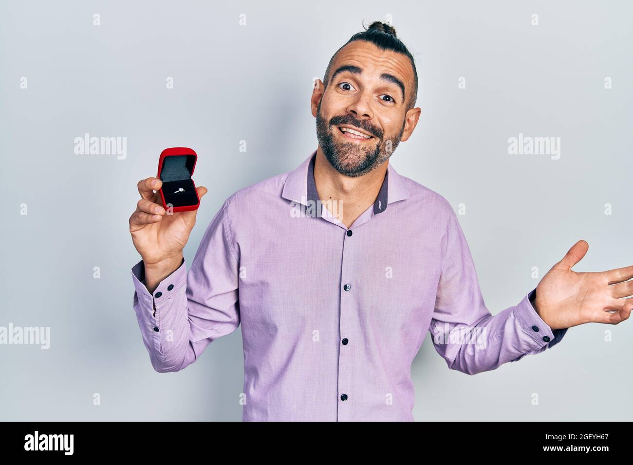 Young hispanic man holding engagement ring for proposal celebrating ...
