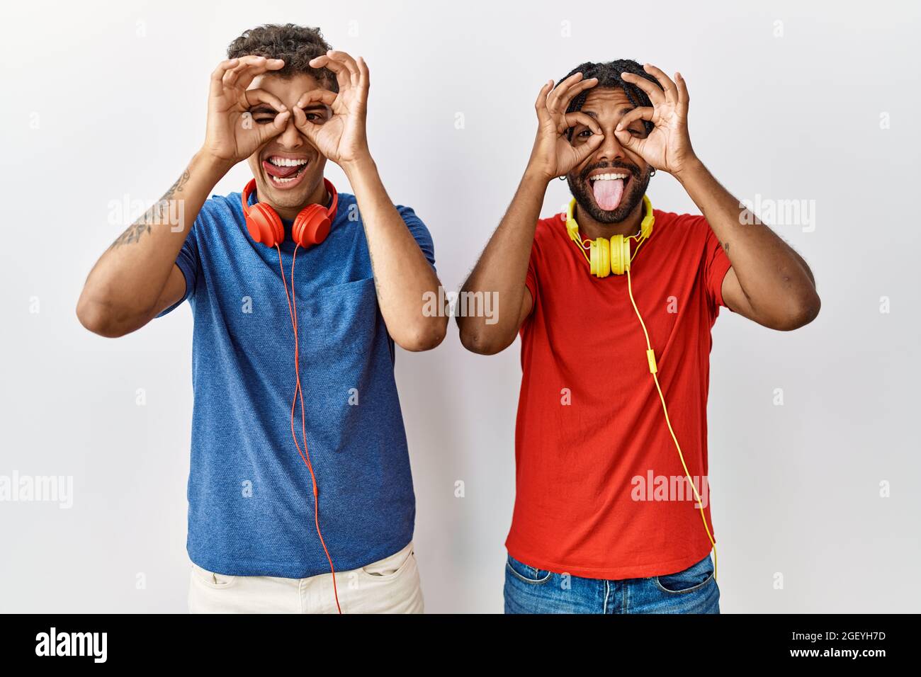 Young hispanic brothers standing over isolated background wearing ...