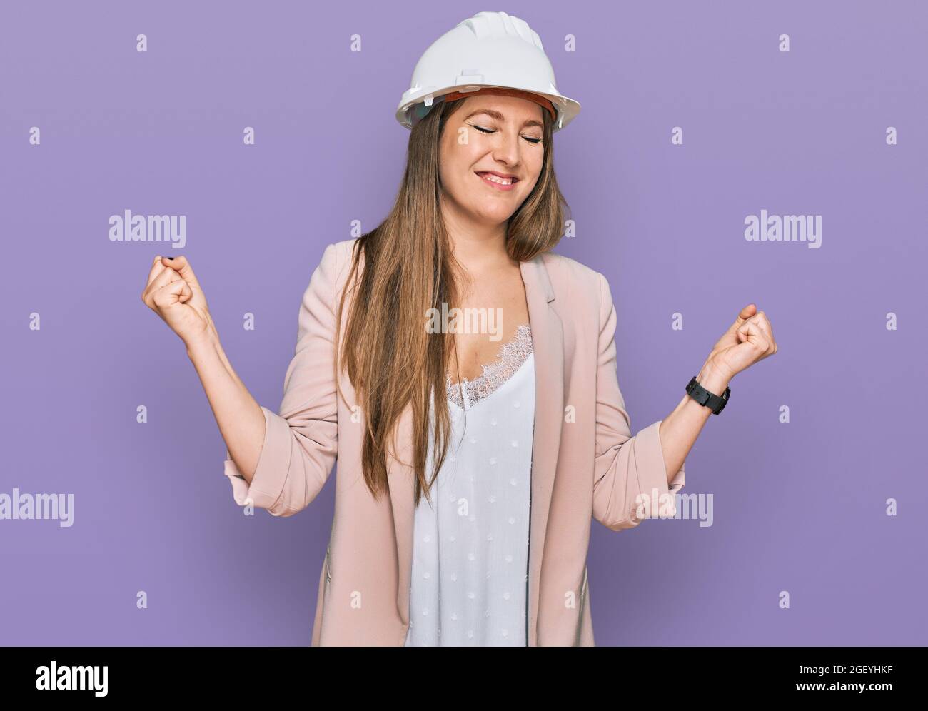 Young blonde woman wearing architect hardhat very happy and excited ...