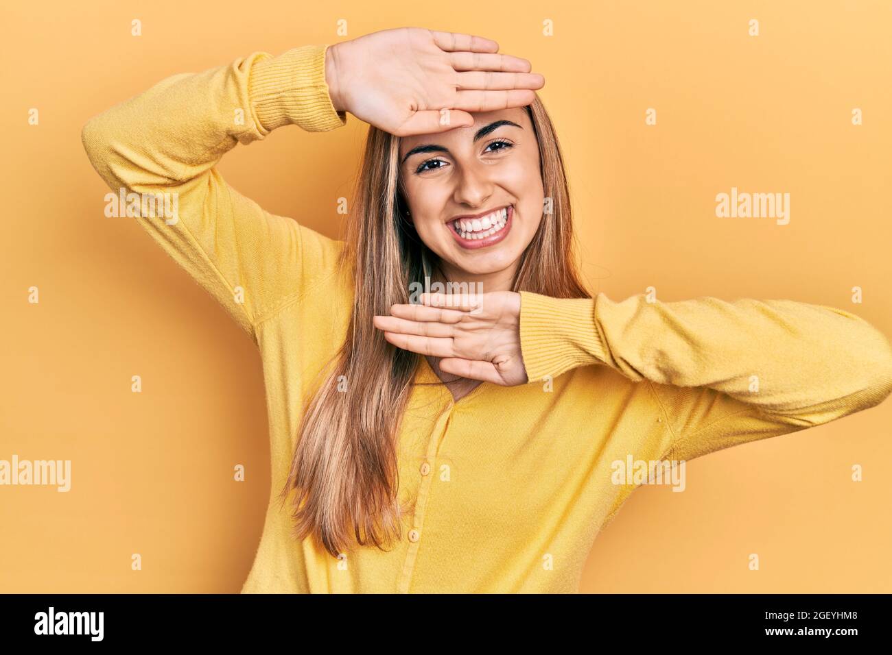 Beautiful hispanic woman wearing casual yellow sweater smiling cheerful ...
